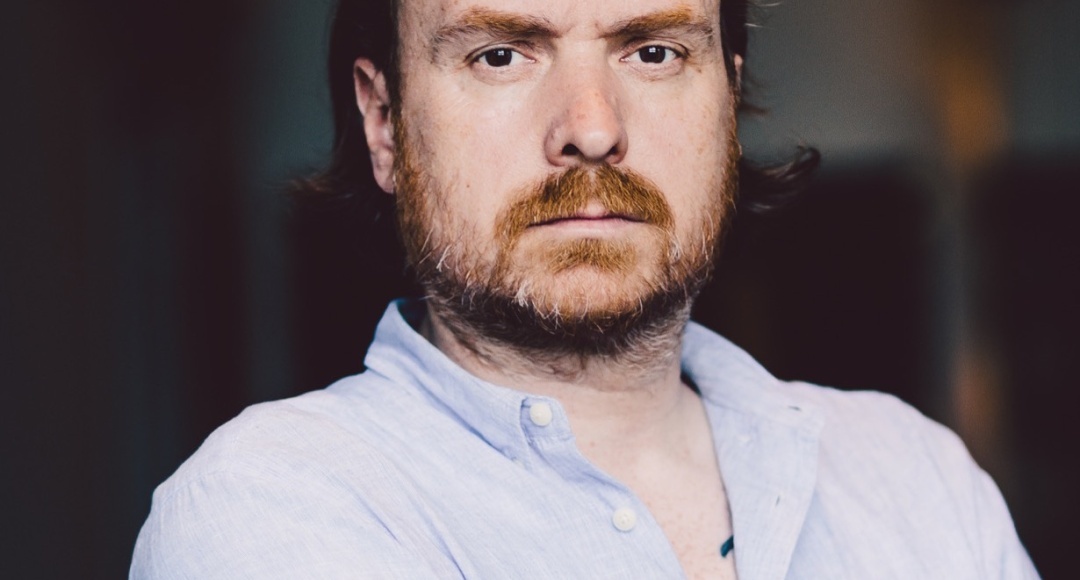 Nick Grgic nimmt auf dem fischerAppelt-Regiesessel Platz